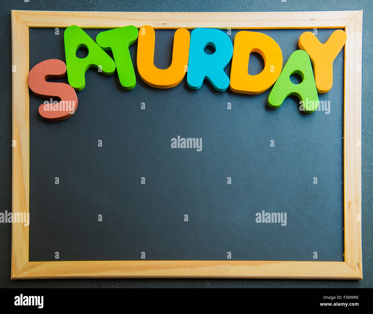 Colorful wooden word Saturday on black board Stock Photo - Alamy