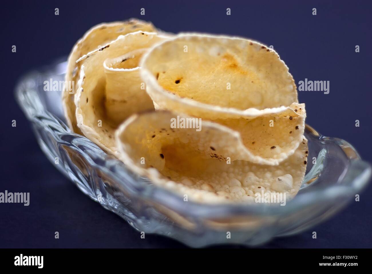 Delicious Indian Indian Papadum crisps in a glass bowl Stock Photo - Alamy