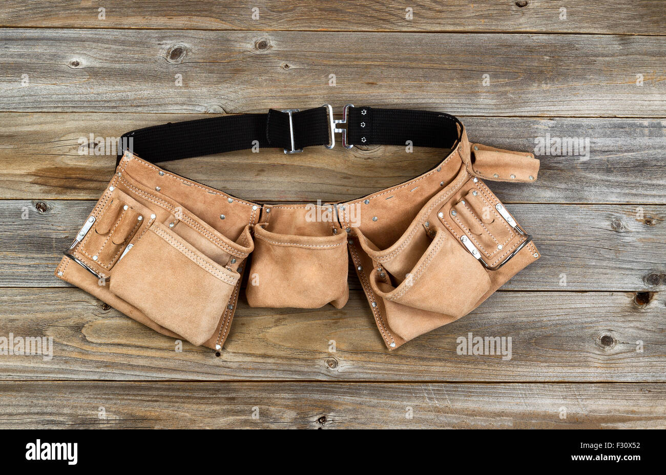 Traditional leather tool belt on rustic wooden floor Stock Photo - Alamy