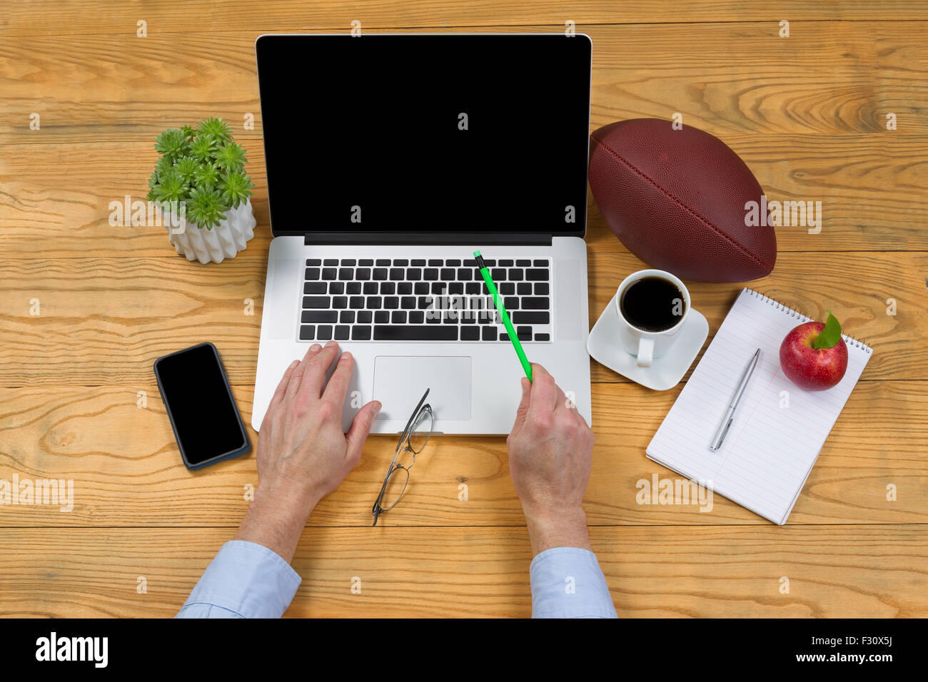 High angled view of male hand holding pencil, point at screen, while ...