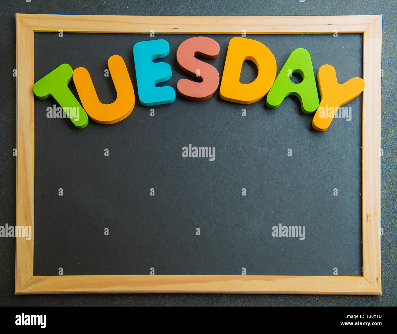 Colorful wooden word Tuesday on black board Stock Photo - Alamy