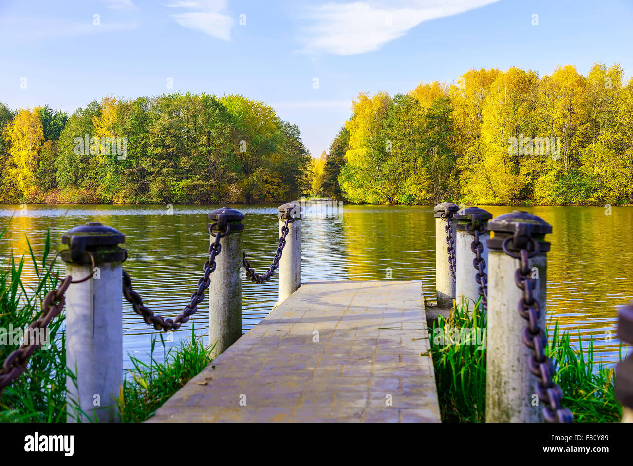 View on Stone Pier with Column and Chain at Lake and Colourful Trees at ...