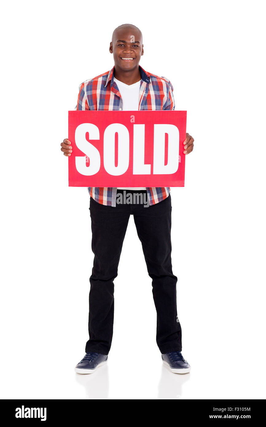 happy young African man holding a sold sign against white background ...