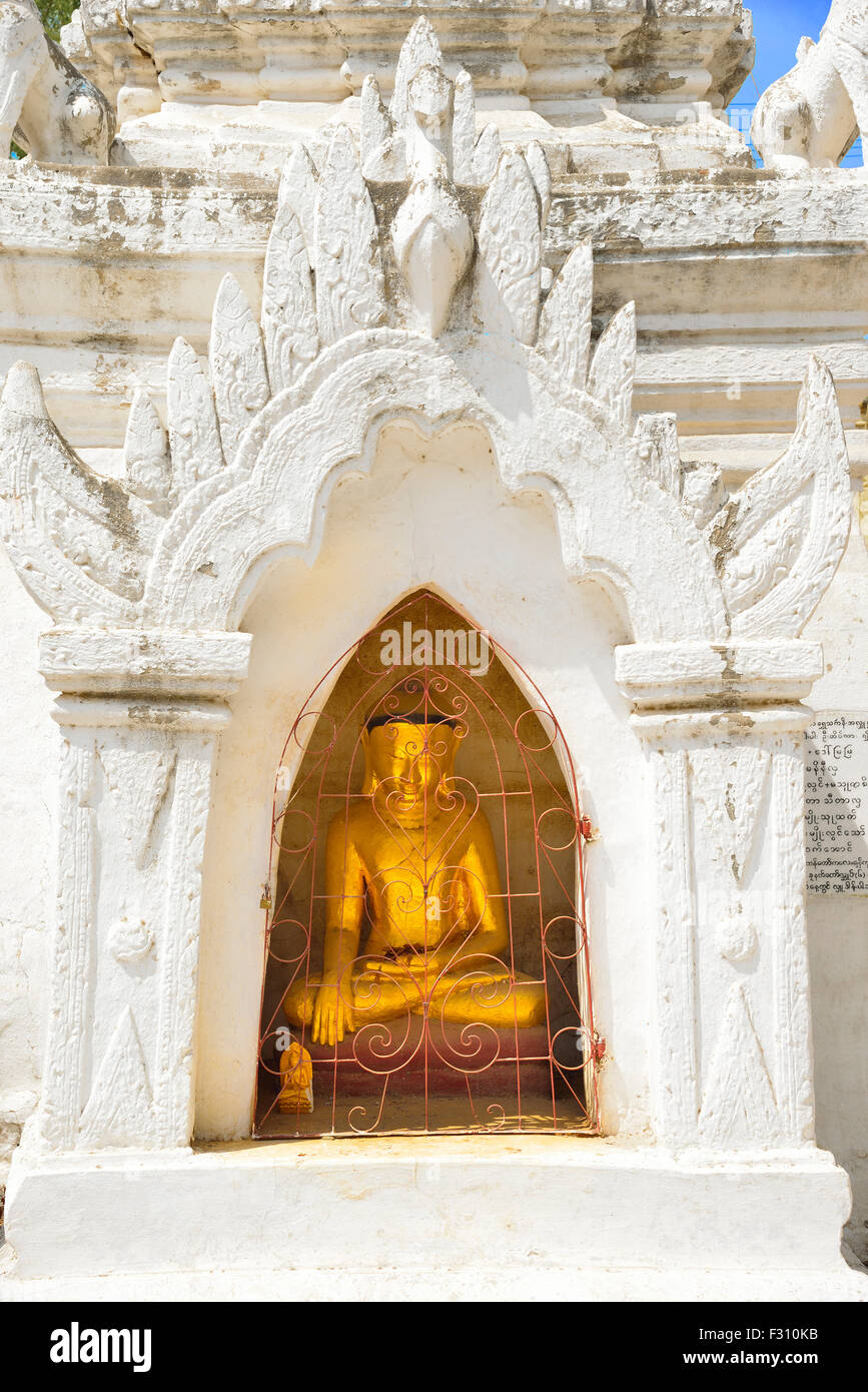 Gold Budda seated in white painted shrine in the grounds of Shwezigon ...