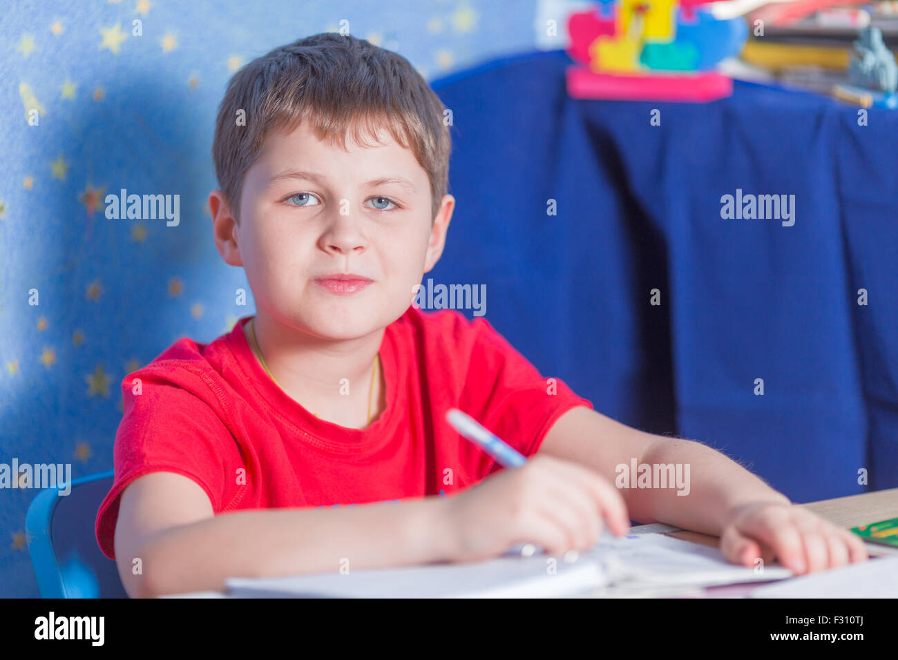 Boy sitting and making his homework writing Stock Photo - Alamy
