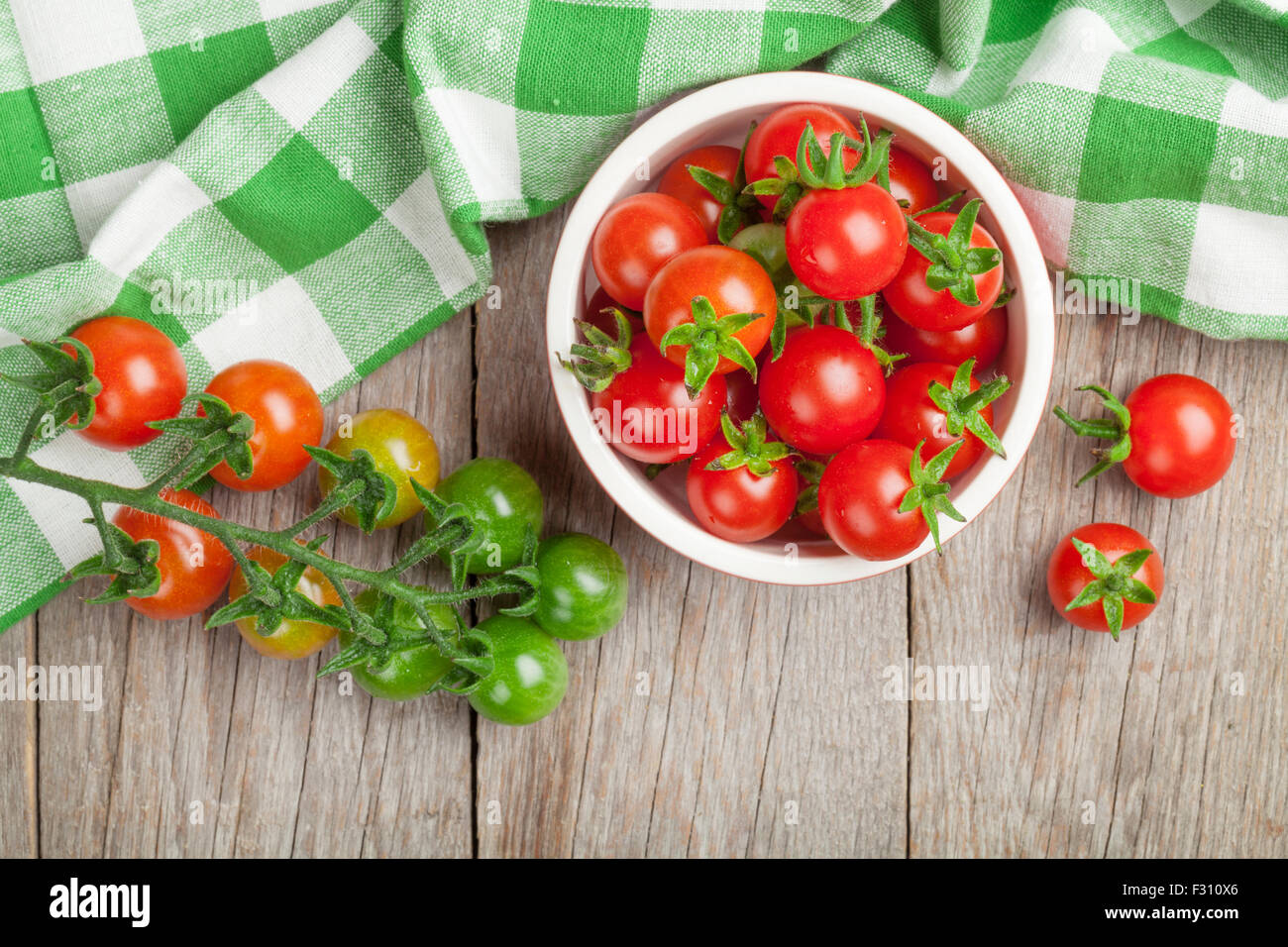 Cherry tomatoes bowl on wooden table. Top view Stock Photo - Alamy