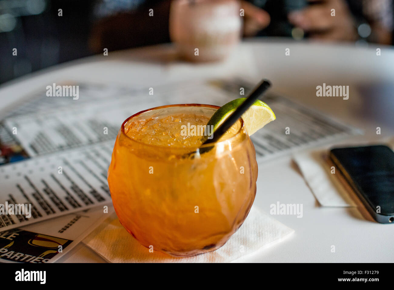 Cocktail on a table with menu Stock Photo - Alamy