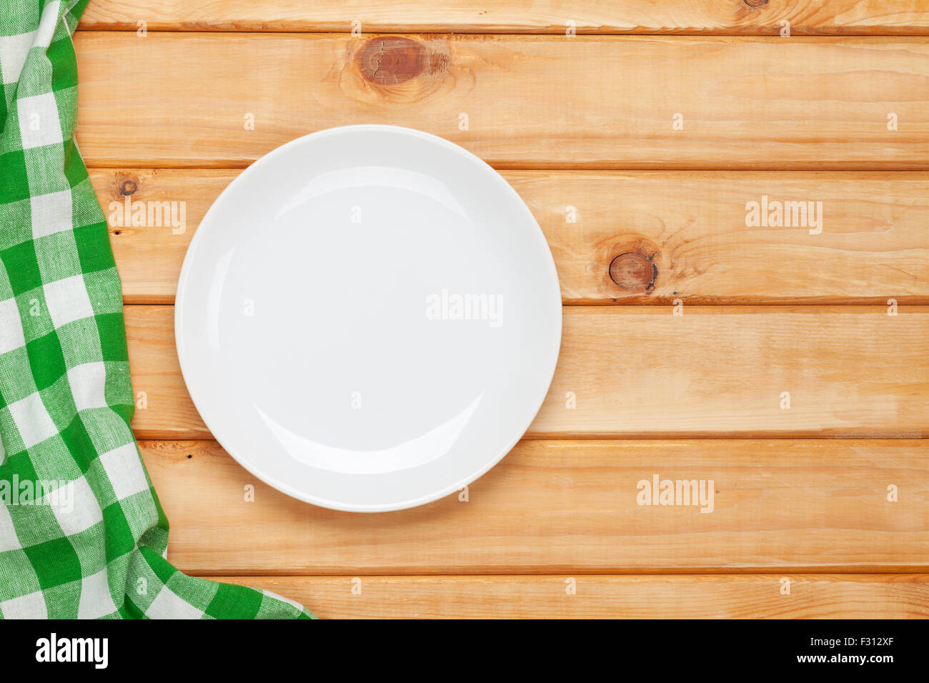 Empty plate and towel over wooden table background. View from above ...