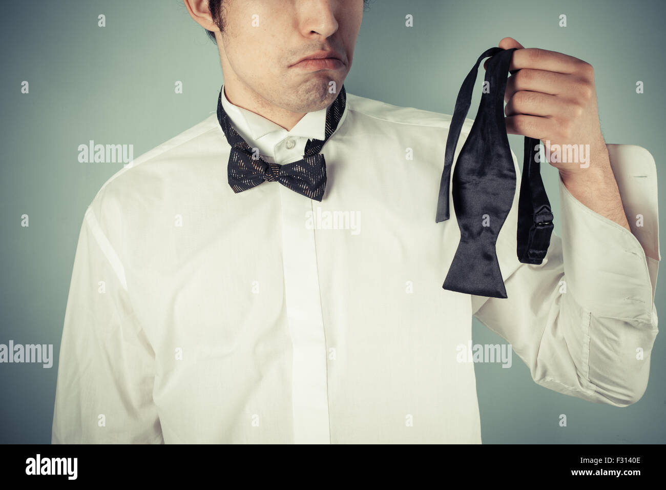 Young man is sad he couldn't tie his own bow tie Stock Photo - Alamy