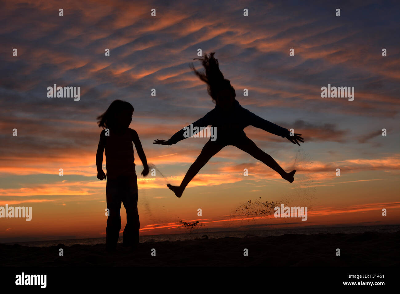 Children silhouette as they jump and enjoy the sunset Stock Photo - Alamy