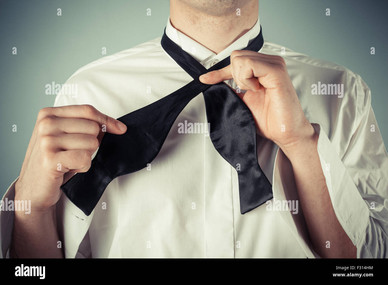 Young man is showing how to tie a formal bow tie Stock Photo - Alamy