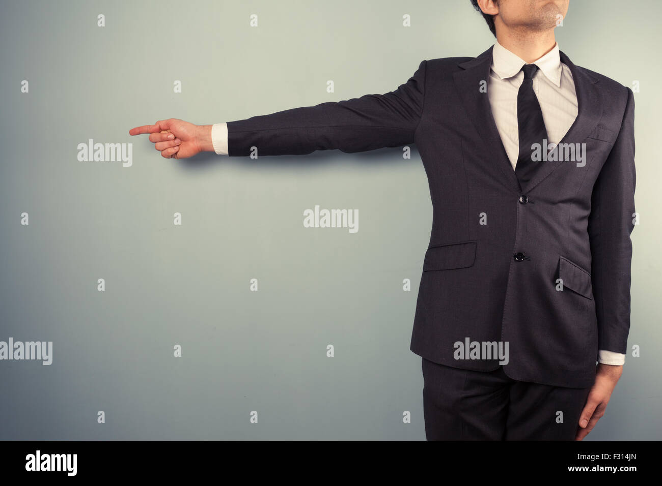 A young businessman is pointing left Stock Photo - Alamy
