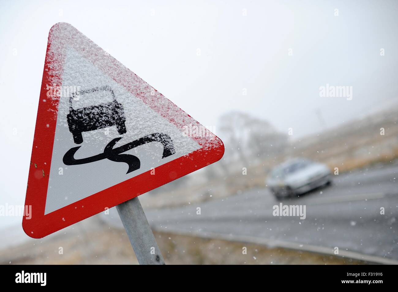 A road sign covered in snow warning car drivers of hazardous driving ...