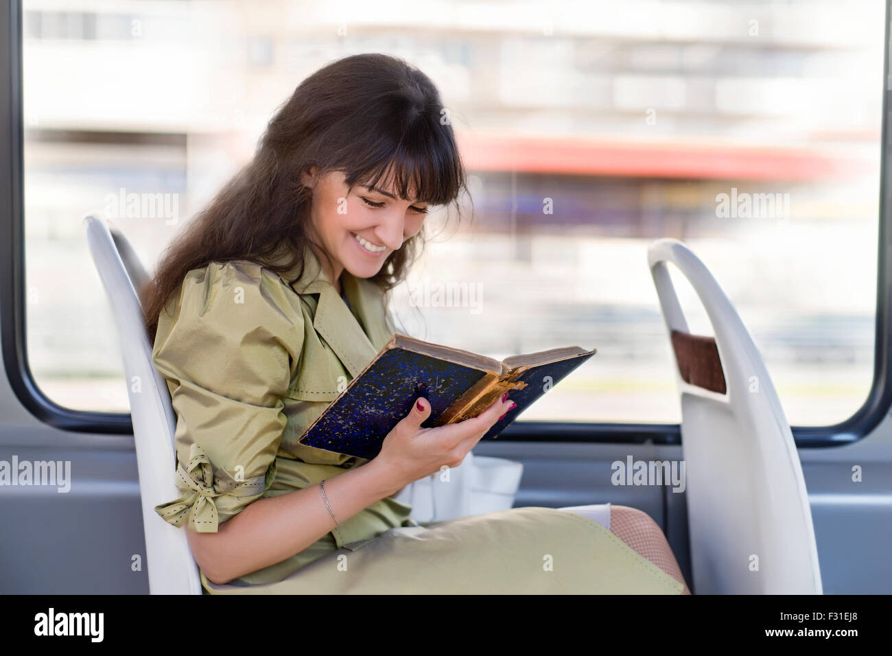 young happy woman reading antique book in the moving tram Stock Photo ...