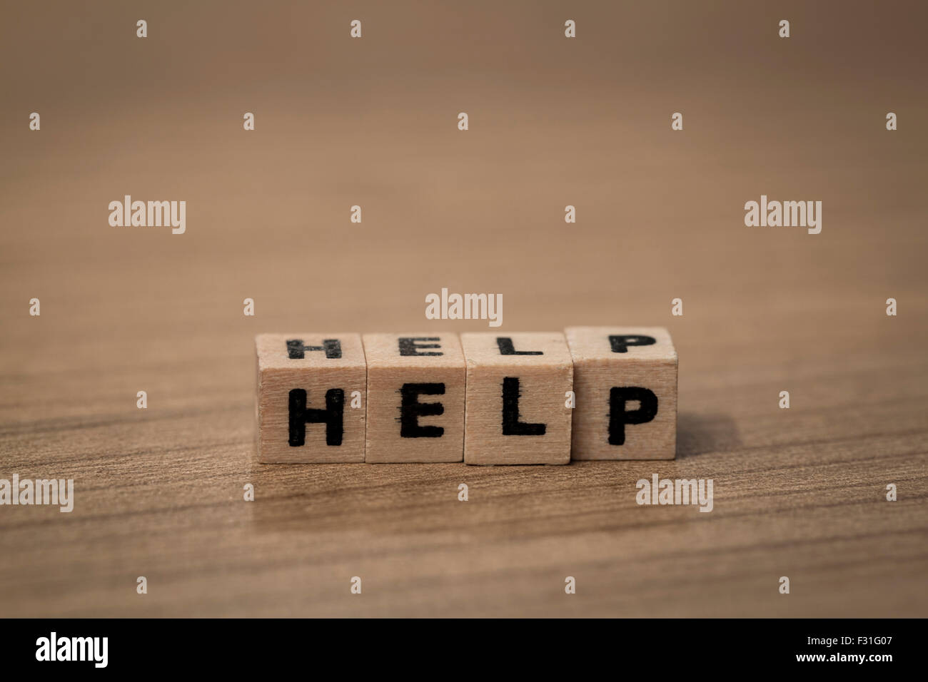 Help written in wooden cubes on a desk Stock Photo - Alamy