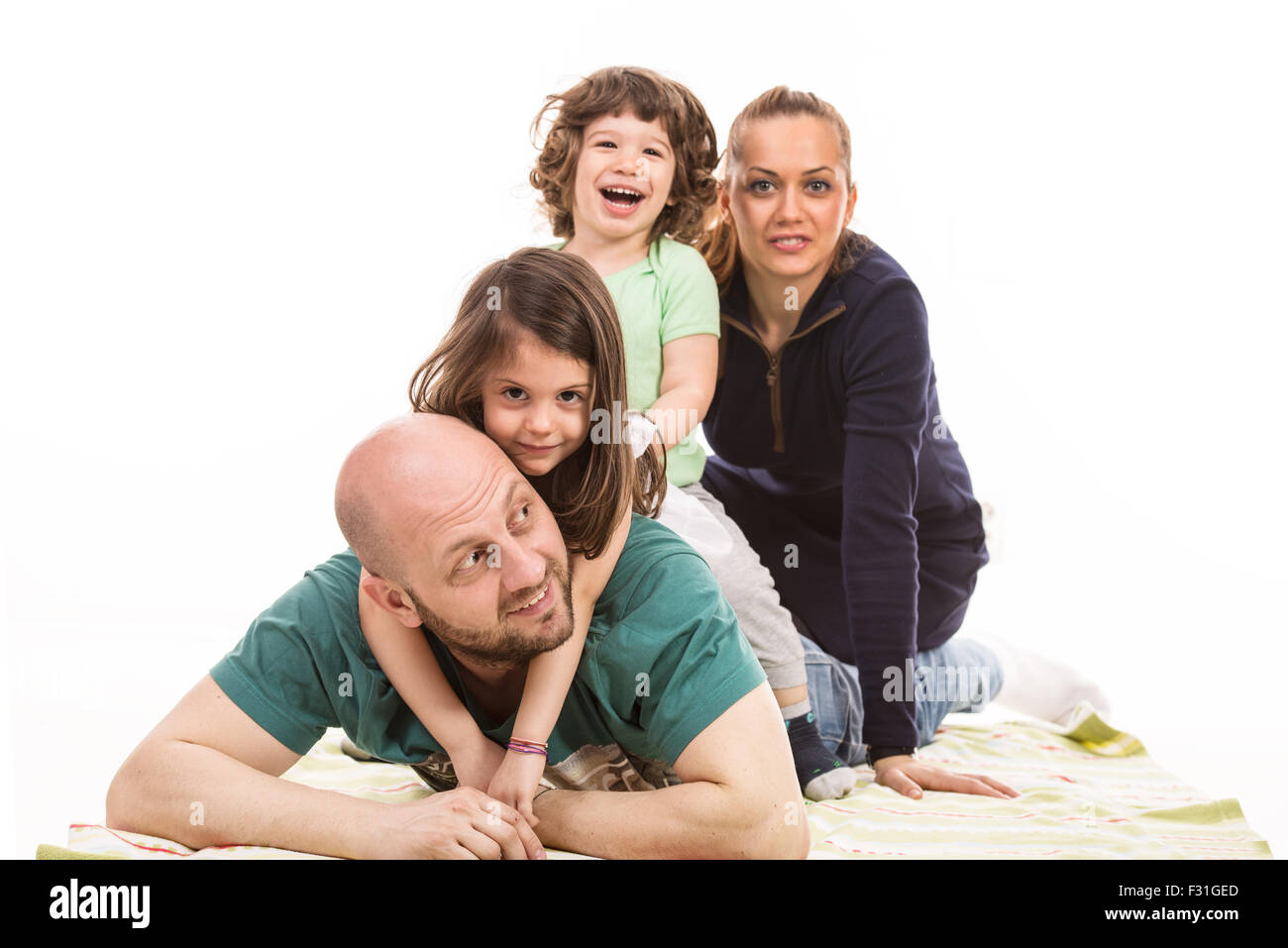 Piled happy family of four members having fun home Stock Photo - Alamy