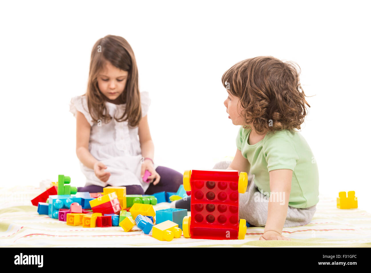 Two little kids playing with bricks toys home Stock Photo - Alamy