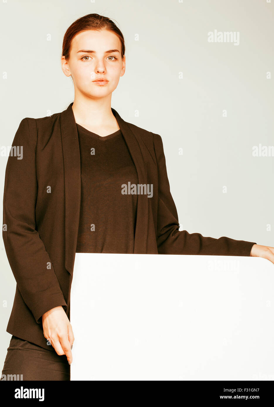 young pretty brunette girl with placard on white background wearing ...
