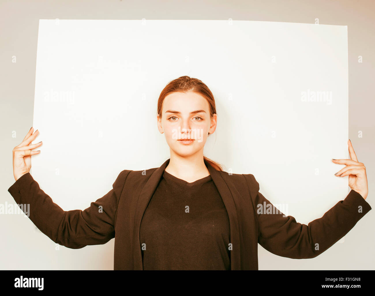 young pretty brunette girl with placard on white background wearing ...