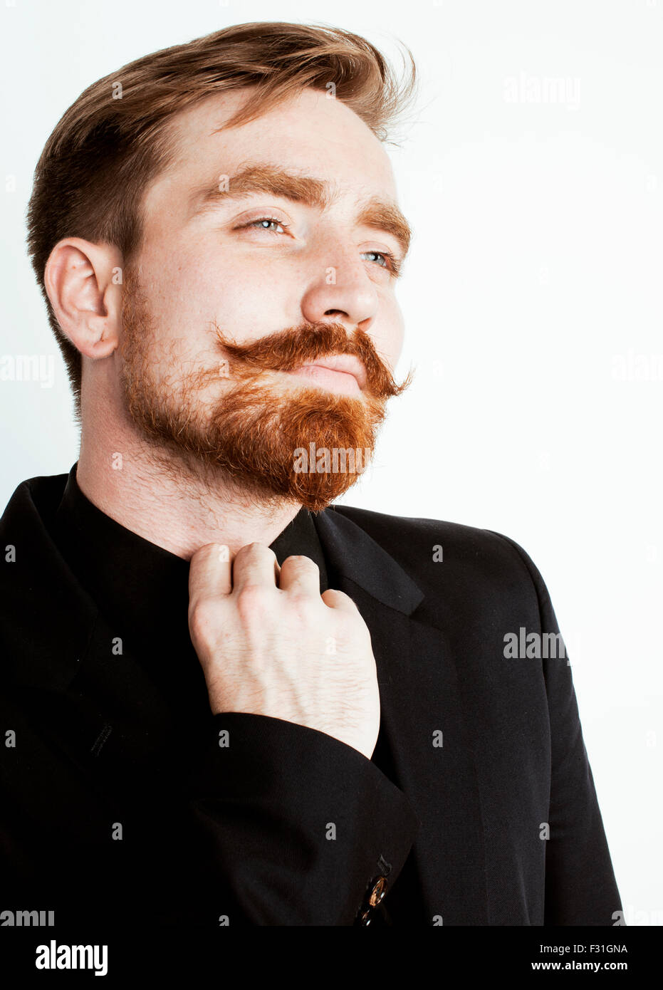 young red hair man with beard and mustache in black suit on white ...