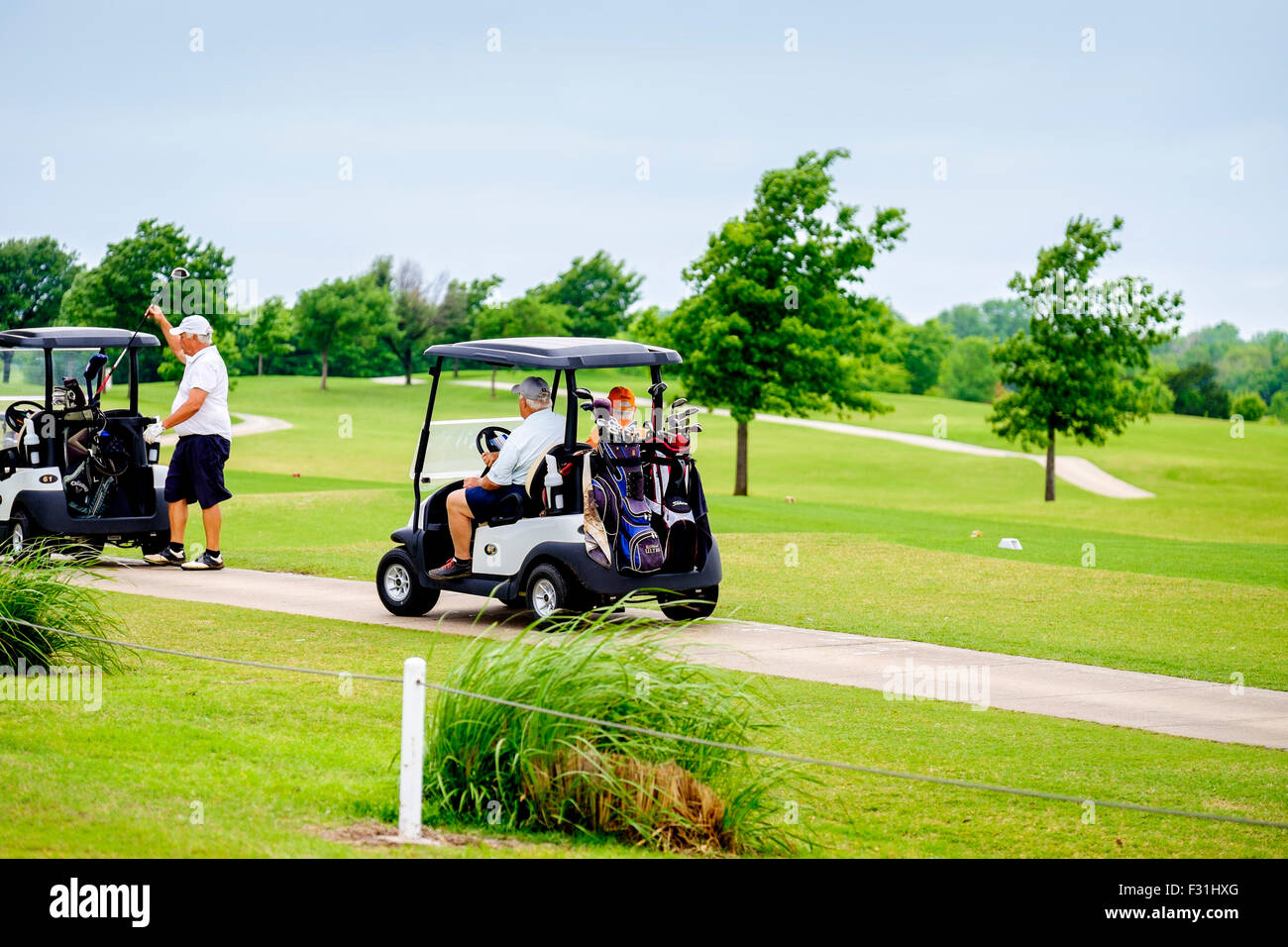 Men ride in golf carts on a cart path during a tournament at Hefner ...