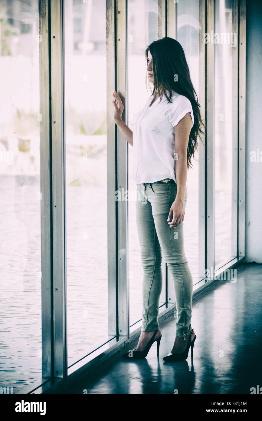 Young woman standing by the window Stock Photo - Alamy