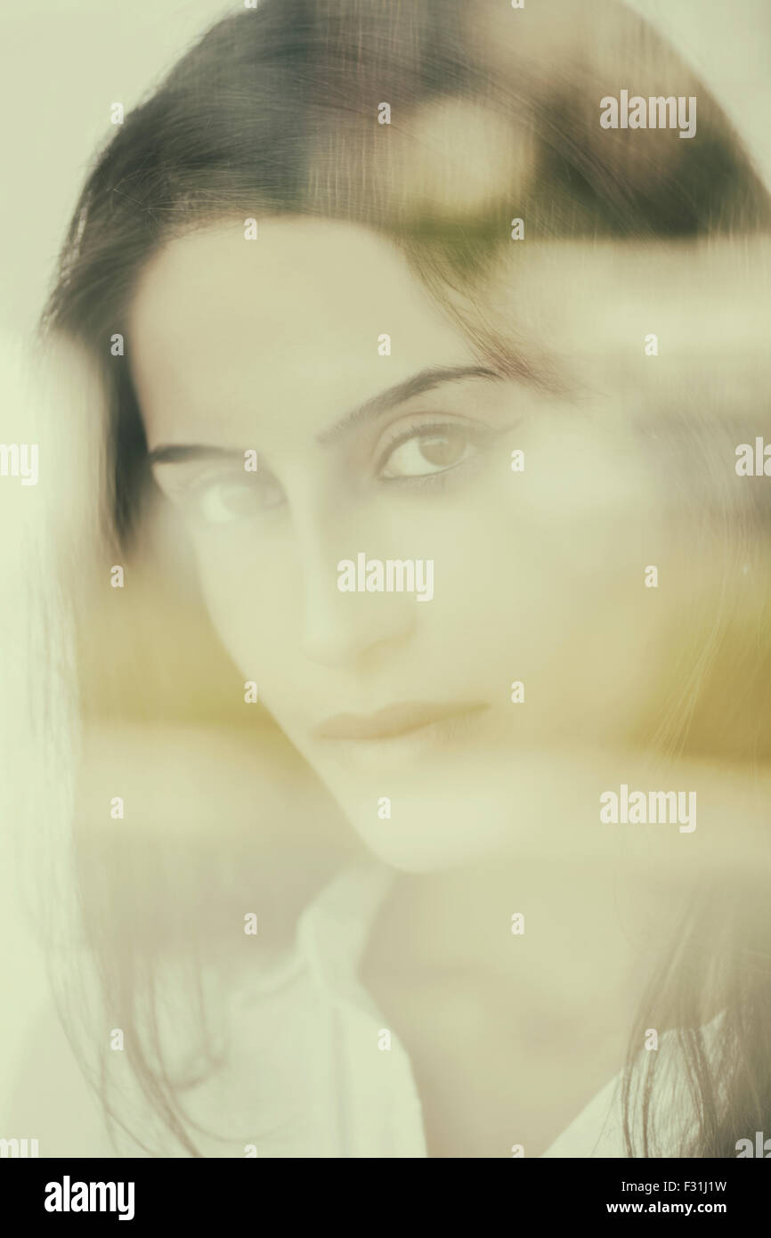 Beautiful young woman looking through the glass Stock Photo - Alamy