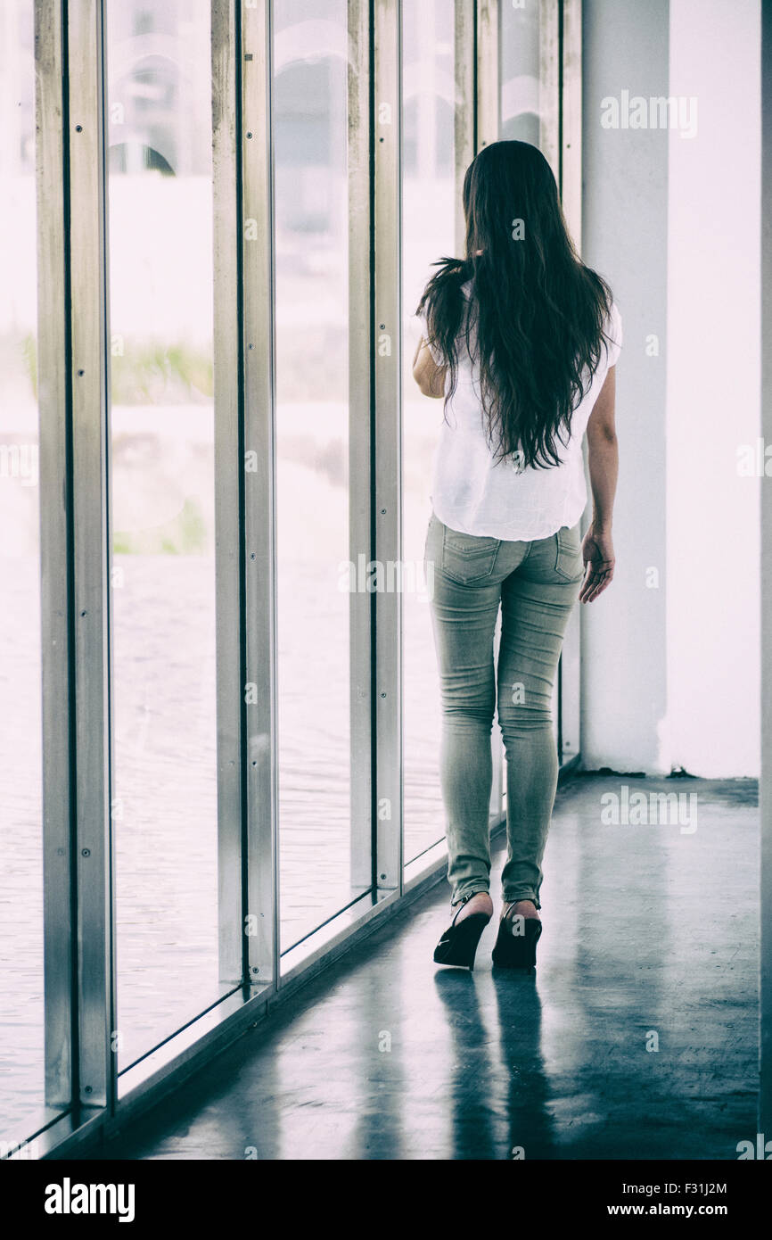 Young woman standing by the window Stock Photo - Alamy