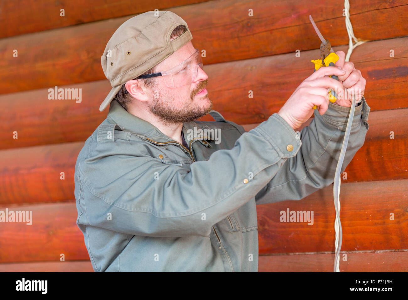 Electrician making an electrical wiring in wooden house Stock Photo - Alamy