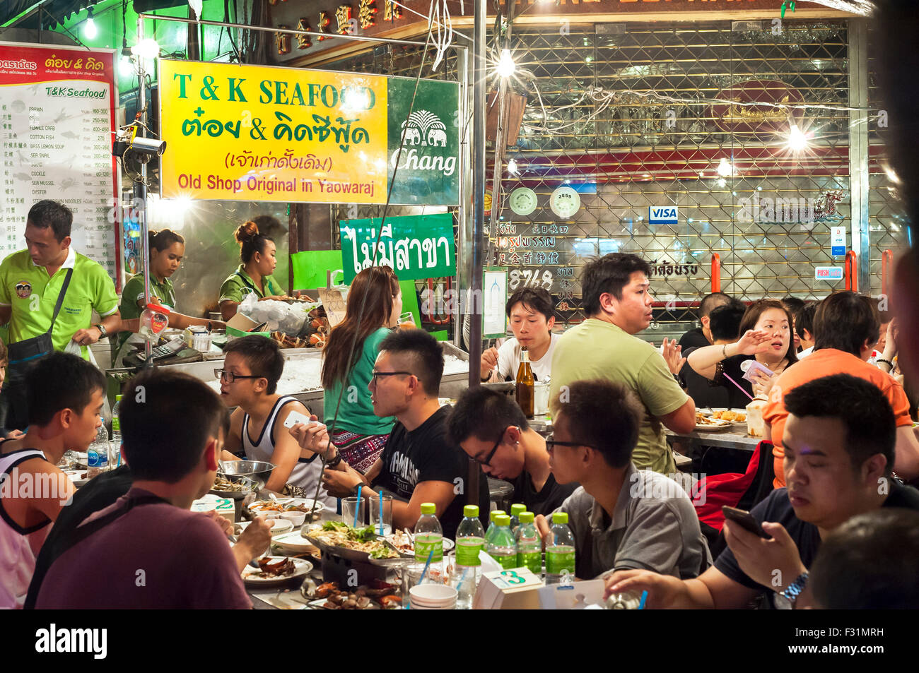BANGKOK, THAILAND - JUNE 2015 - People eating at tables on the street ...