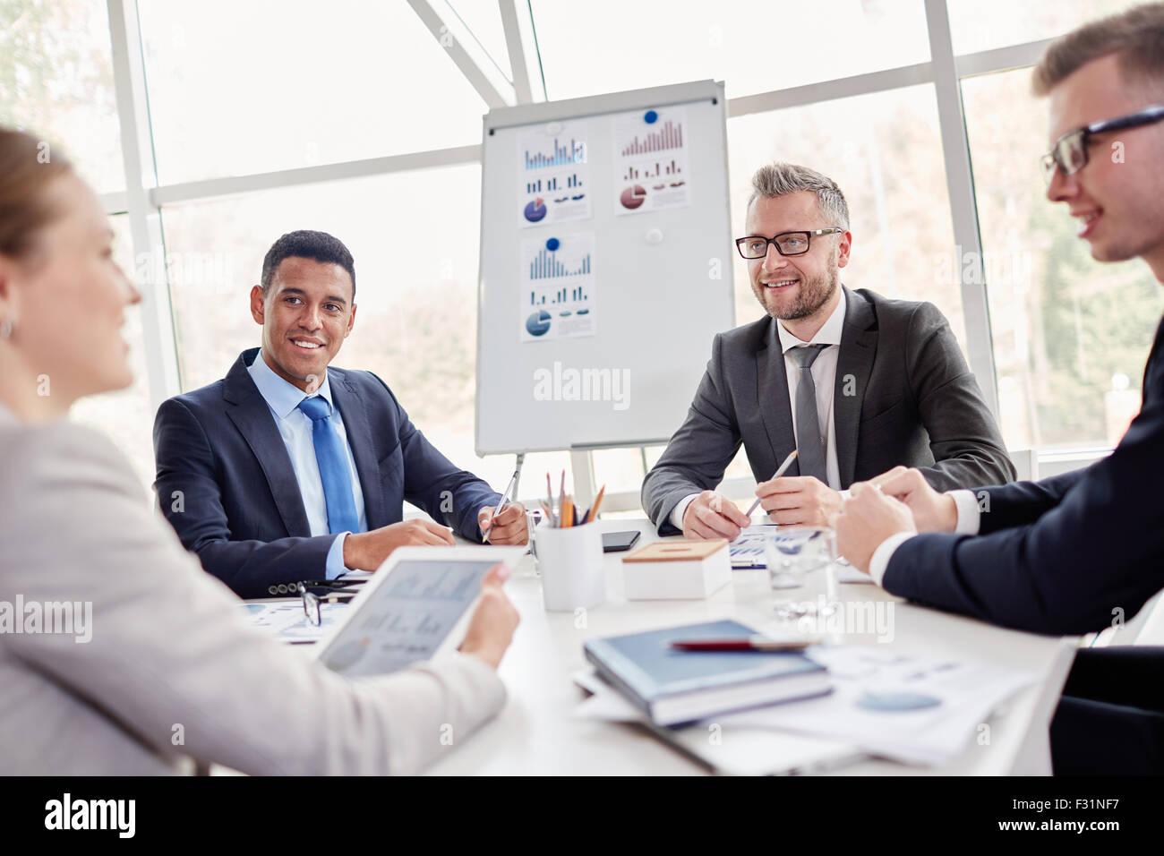 Group of confident employees listening to their colleague at meeting in ...