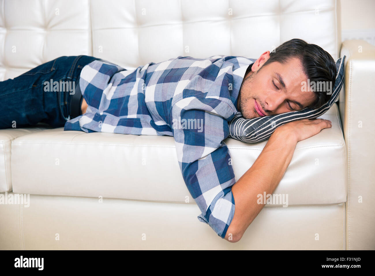 Portrait of a young man resting on cloth in the sofa at home Stock ...