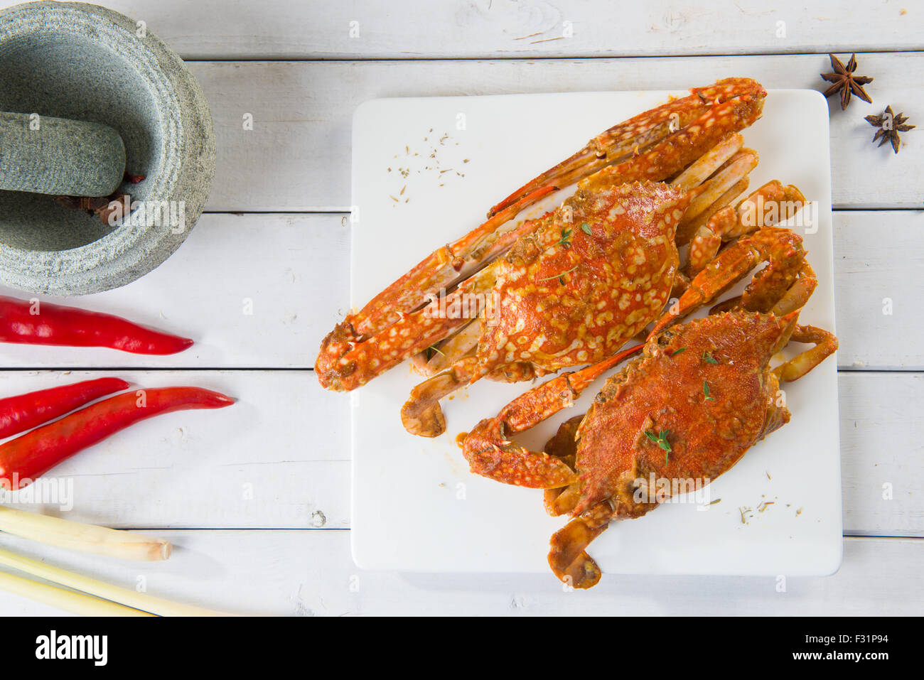 Top view cooked delicious hot and spicy sauce blue crab on white plate ...