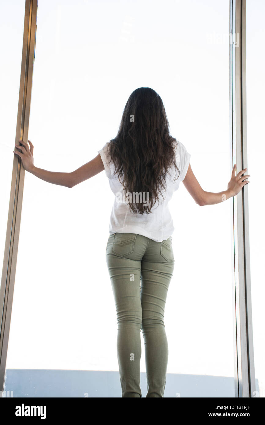Rear view of a slim woman standing by the window Stock Photo - Alamy