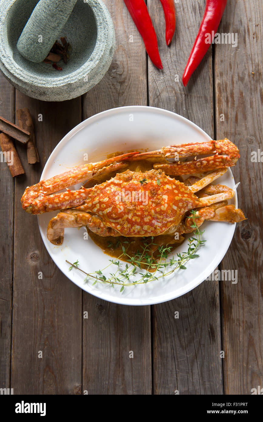 Top view cooked delicious hot and spicy sauce blue crab on white plate ...