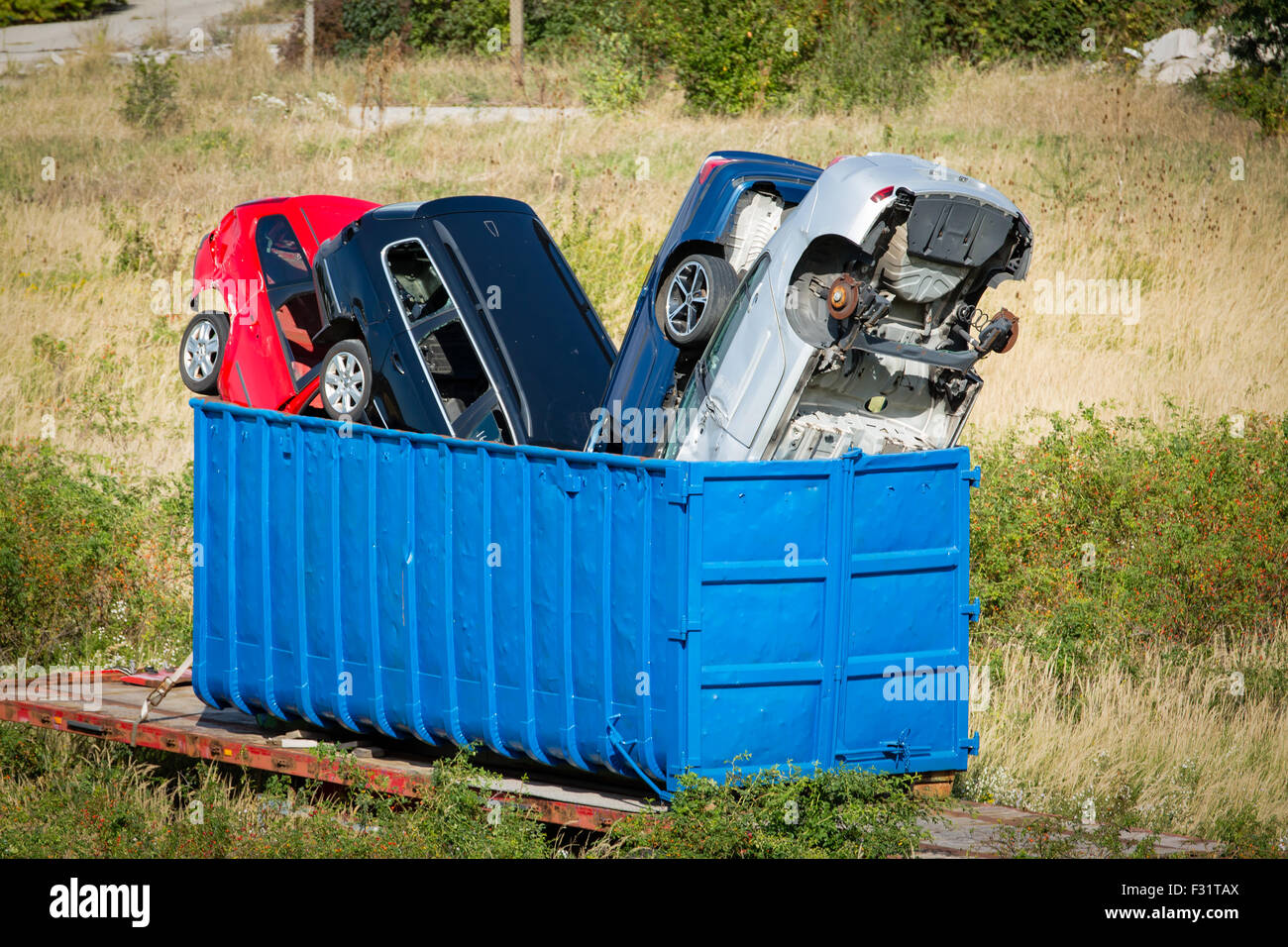 Wrecked cars stacked in a blue container Stock Photo - Alamy