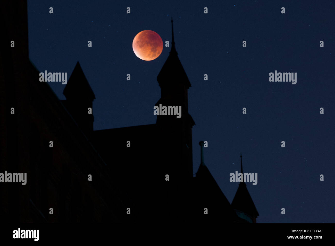 The perigee full moon, or supermoon, appears red on the night sky above ...