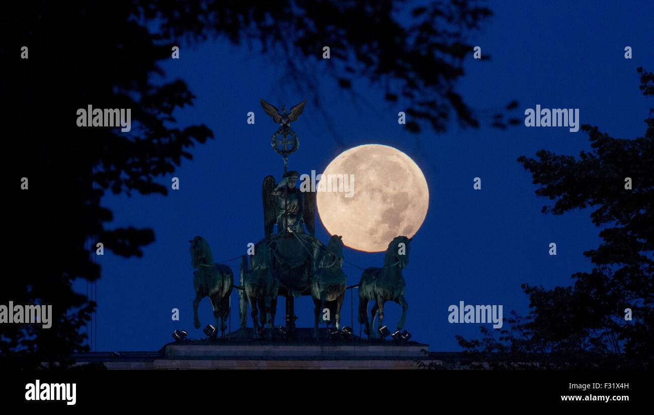 The perigee full moon, or supermoon, appears red behind the quadriga of ...