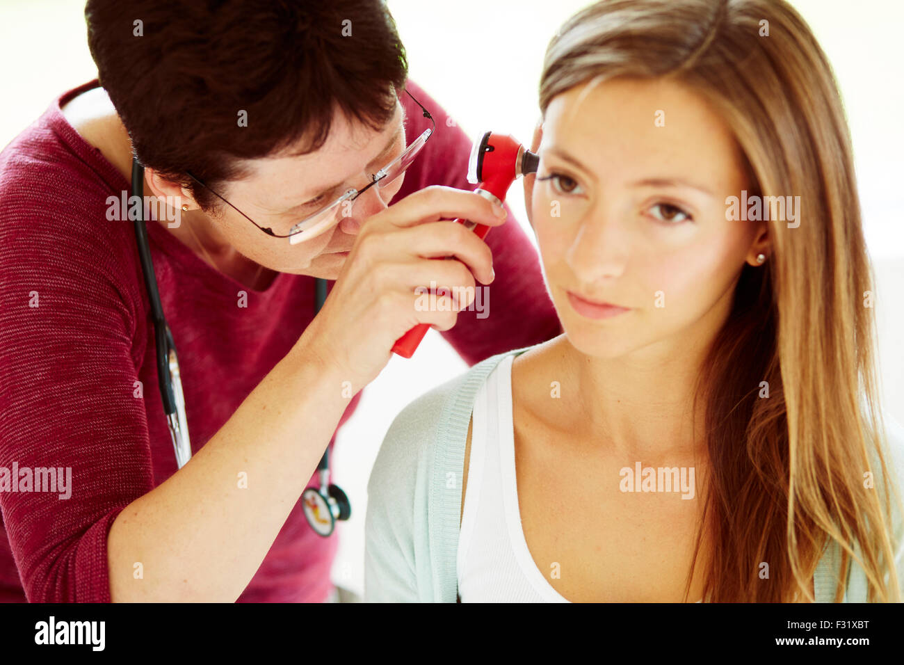 Doctor examining patients ears Stock Photo - Alamy