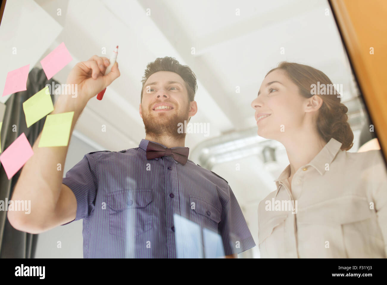 happy creative team writing on blank office glass Stock Photo - Alamy