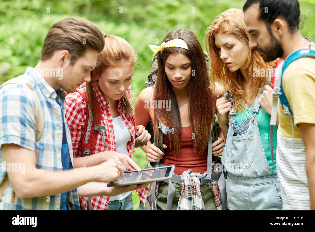 friends with backpacks and tablet pc hiking Stock Photo - Alamy