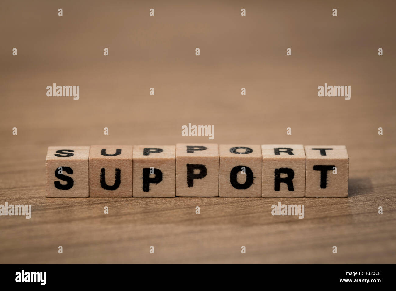 Support written in wooden cubes on a desk Stock Photo - Alamy