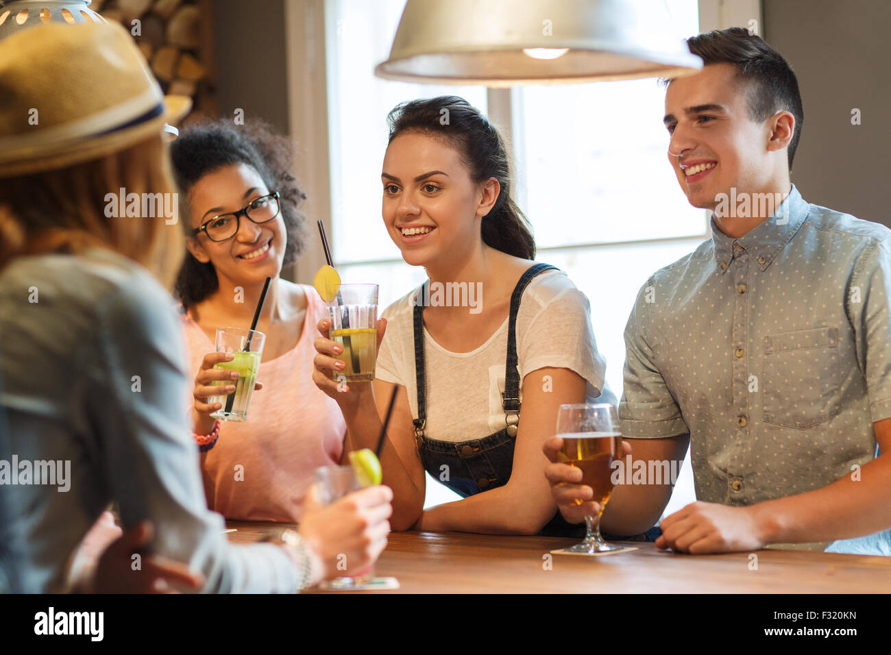 happy friends drinking beer and cocktails at bar Stock Photo - Alamy
