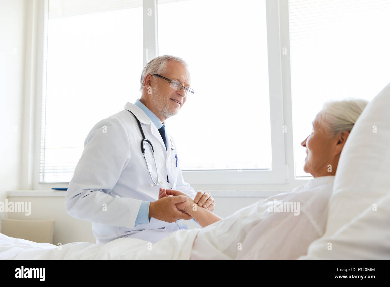 doctor checking senior woman pulse at hospital Stock Photo - Alamy