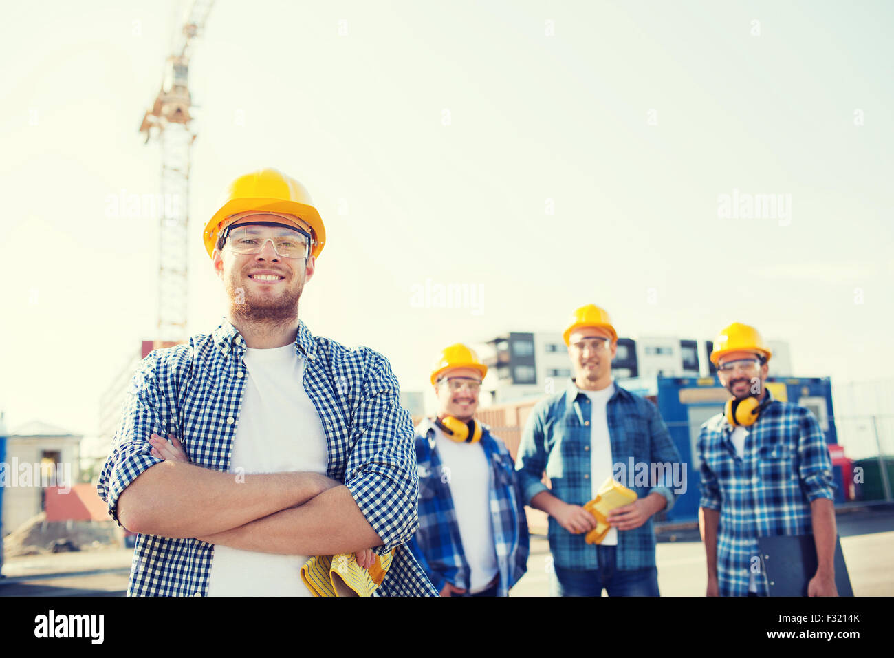 group of smiling builders in hardhats outdoors Stock Photo - Alamy