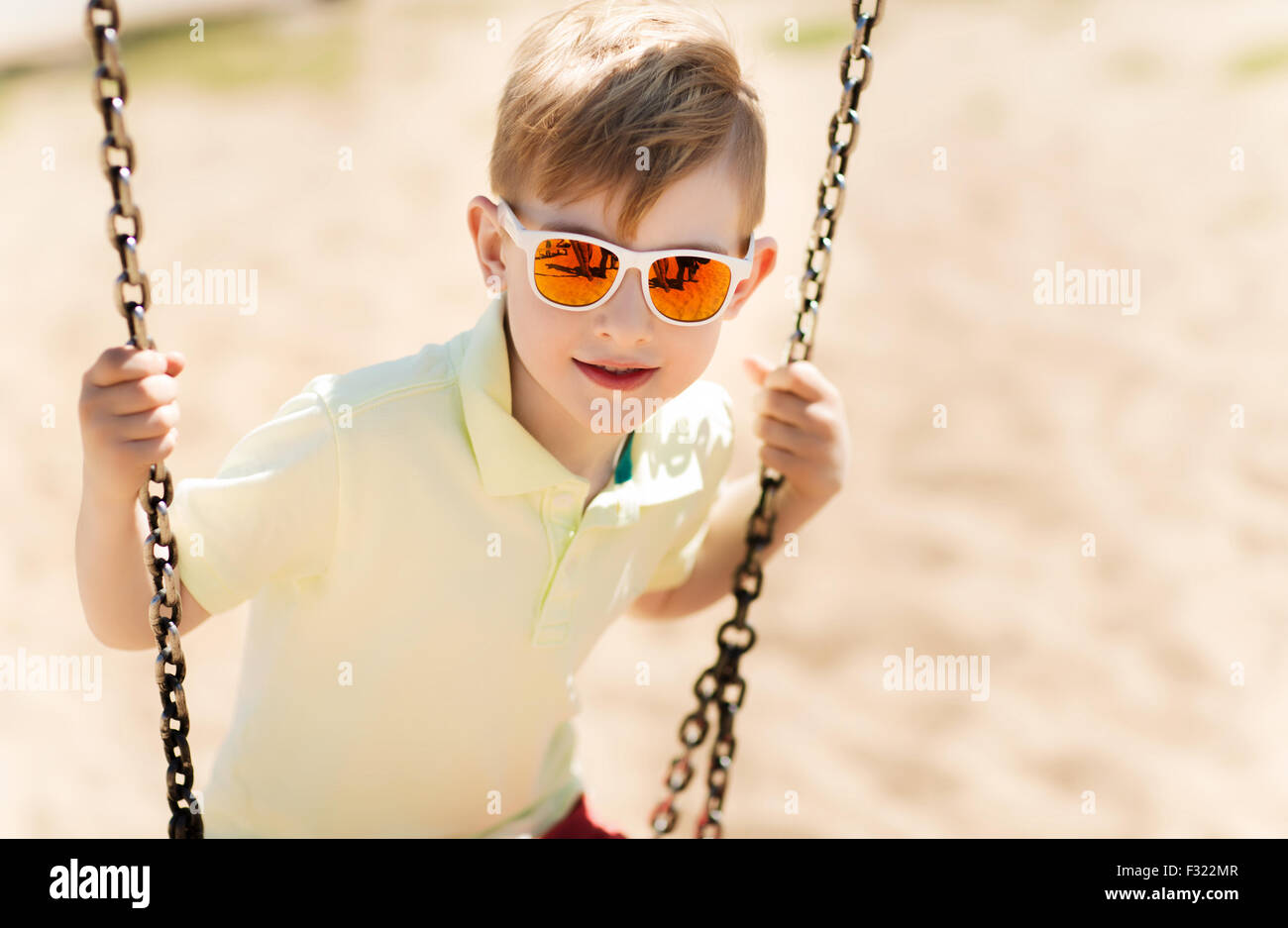 happy little boy swinging on swing at playground Stock Photo - Alamy