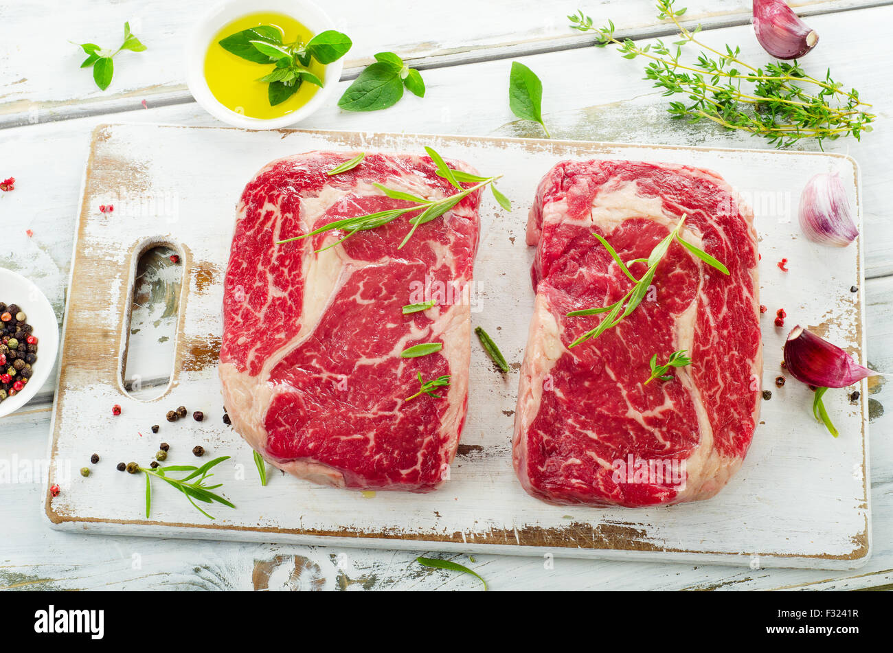 Raw rib eye Steaks on a white cutting board. Top view Stock Photo - Alamy