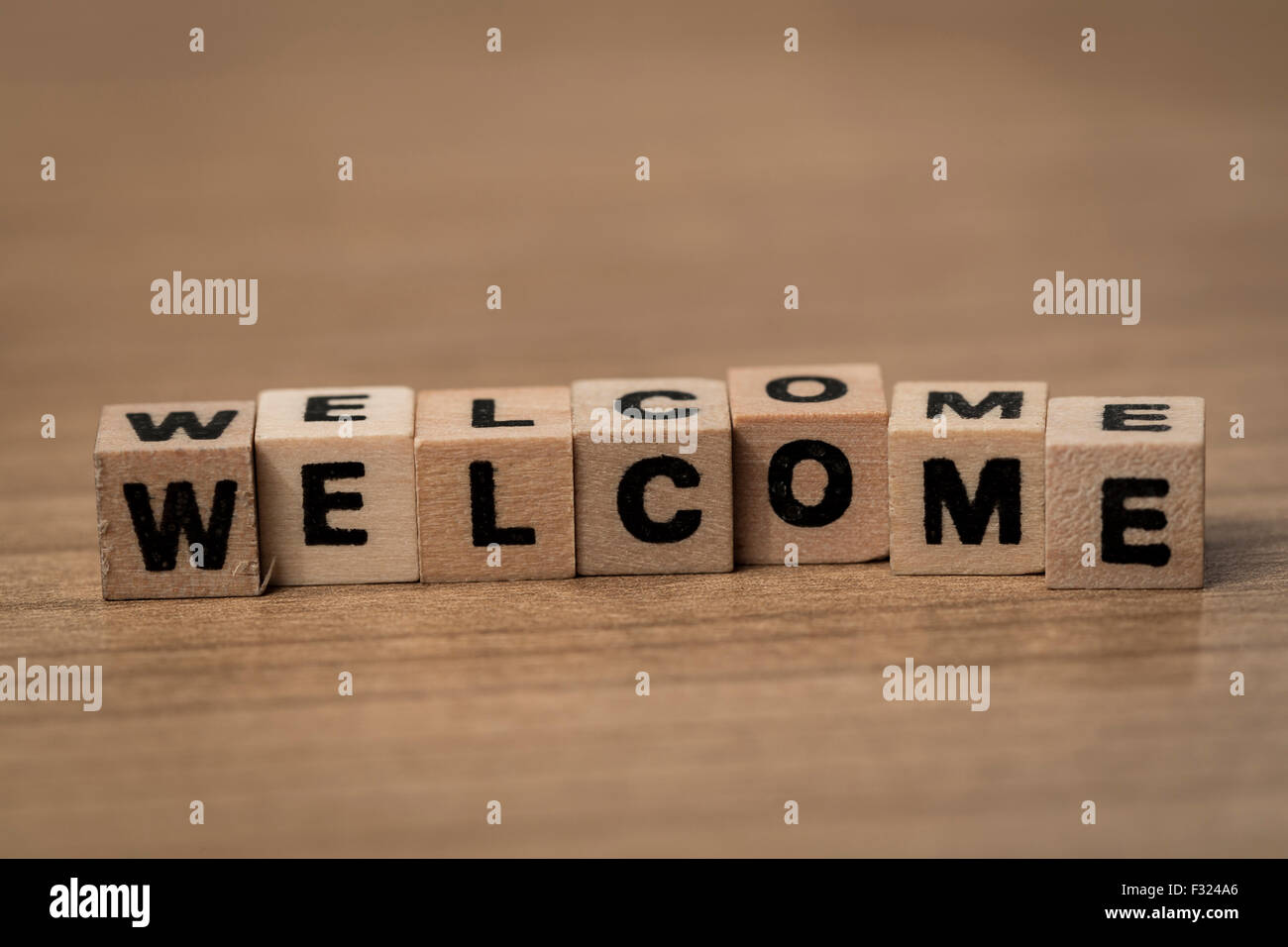 Welcome written in wooden cubes on a desk Stock Photo - Alamy