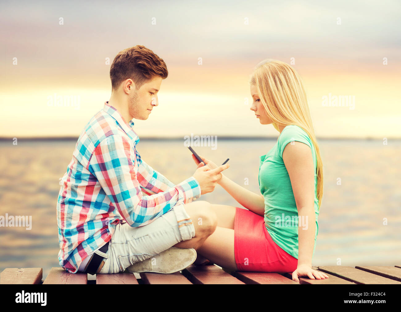 Couple smartphone sitting on bench hi-res stock photography and images ...