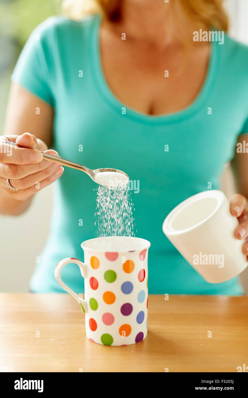Girl pouring sugar on cereal Stock Photo - Alamy